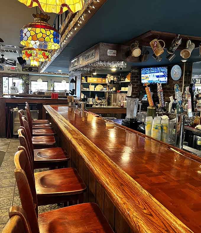 The polished wood bar gleams under Tiffany-style lamps, inviting you to settle in for the long haul.