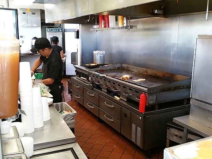The open kitchen means no secrets here, just skilled hands working their magic on that impressive griddle.
