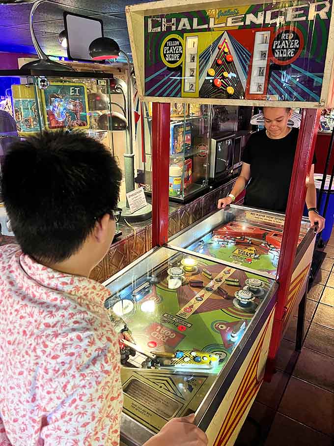 Two players face off at a vintage machine, proving pinball competition never goes out of style.