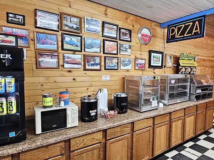 Classic car photos line the wooden walls while you grab a quick slice of pizza or snacks at this cozy counter.