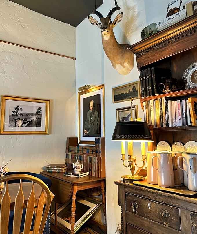 Antique furniture, classical portraits, and that watchful elk overhead transform dining into a proper Victorian gentleman's club experience.
