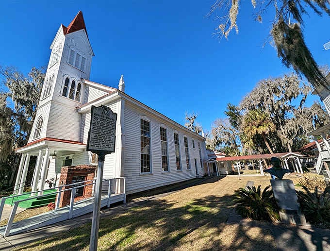 White clapboard and red roof tiles stand proud beneath ancient oaks, a testament to enduring Southern architectural grace.