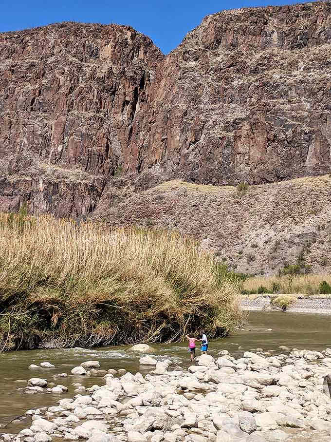 Kids exploring the riverbank discover that the best playground doesn't need swings or slides, just rocks and water.