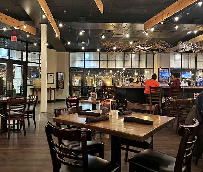 The spacious dining room with that striking branch installation overhead creates an unforgettable ambiance for any occasion.