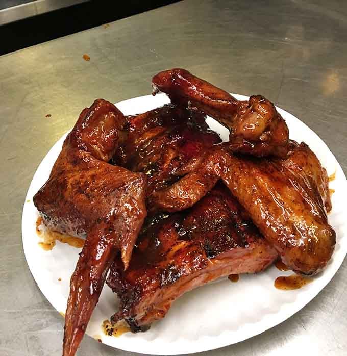 Glossy chicken wings and fall-apart ribs glisten with sauce, proving that smoke and spice make everything nice in life.