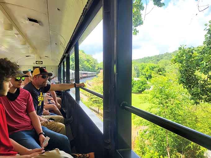Open-air car passengers soaking in mountain views while the breeze does what expensive spa treatments only promise.
