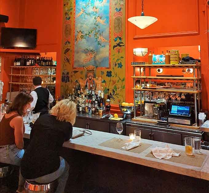 The bar showcases colorful artwork and an impressive spirits collection for serious cocktail enthusiasts everywhere.