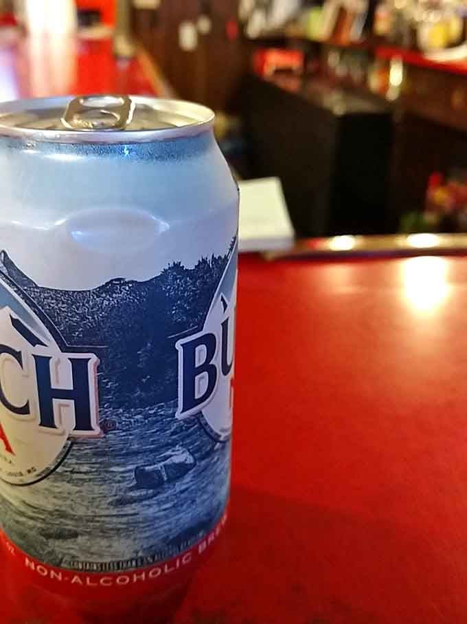 An ice-cold Busch on a bright red table, the perfect companion for tackling that legendary fried chicken.