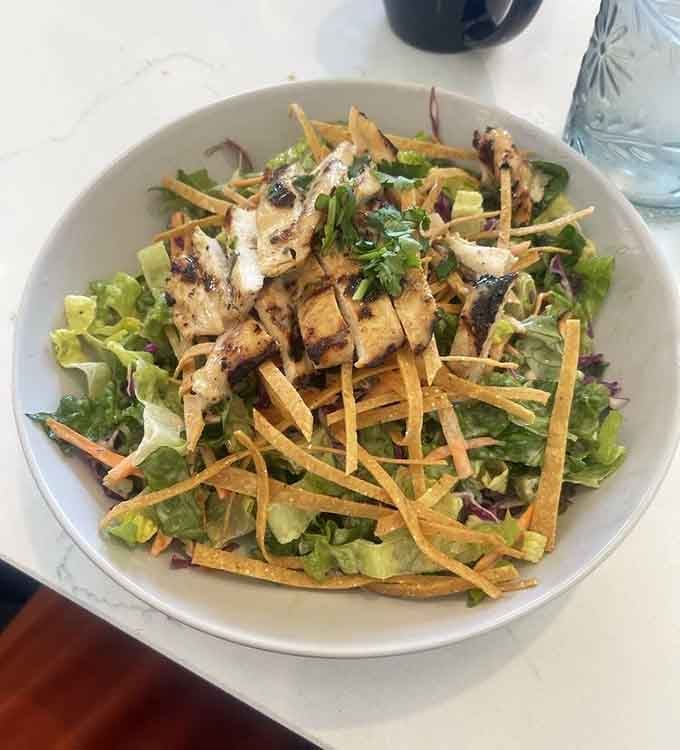 Crispy wonton strips crown grilled chicken over fresh greens in this satisfying salad creation.