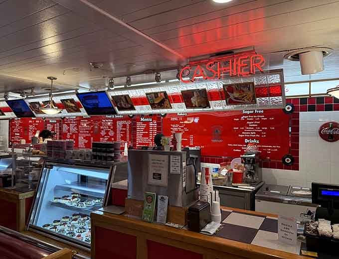 The "Cashier" sign glows in neon red above a counter where milkshakes are made and sweet dreams come true.
