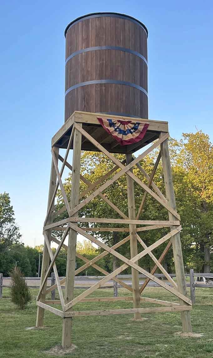 The water tower rises above the settlement, decorated with patriotic bunting and serving as a landmark visible throughout the town.