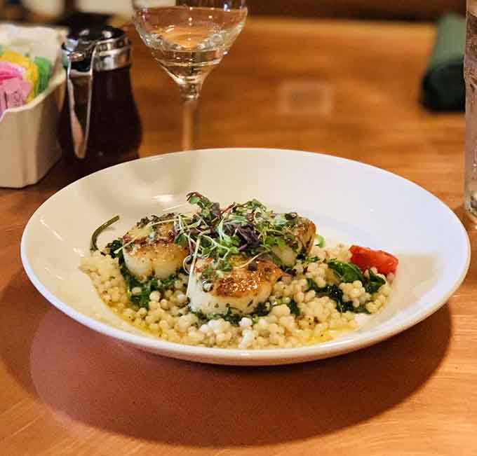 Seared scallops resting on a bed that looks almost too pretty to eat, but you absolutely will anyway.