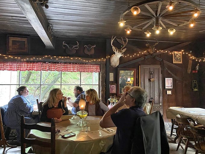 Diners enjoying their meals beneath mounted deer heads and twinkling lights, because ambiance matters when you're making memories in mountains.
