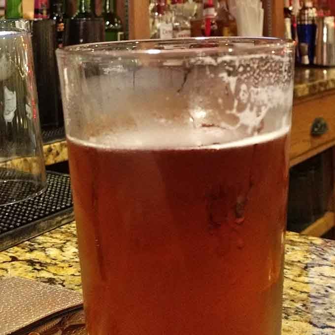 A cold beer waiting patiently at the bar, ready to complement whatever delicious decision you make tonight.