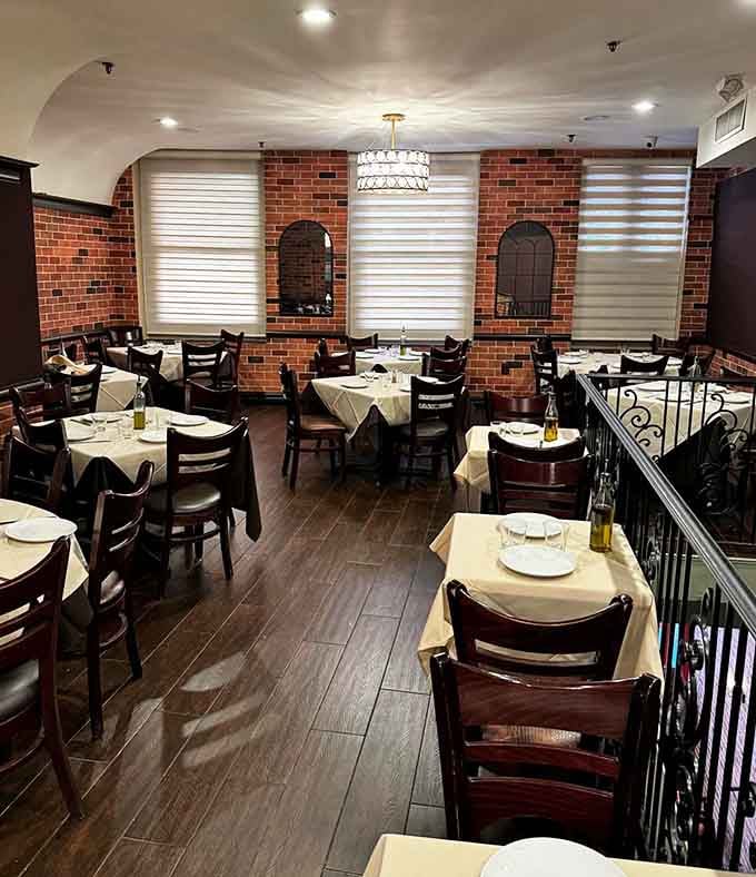 Exposed brick and white tablecloths create that classic Italian-American vibe where every meal feels like a special occasion.
