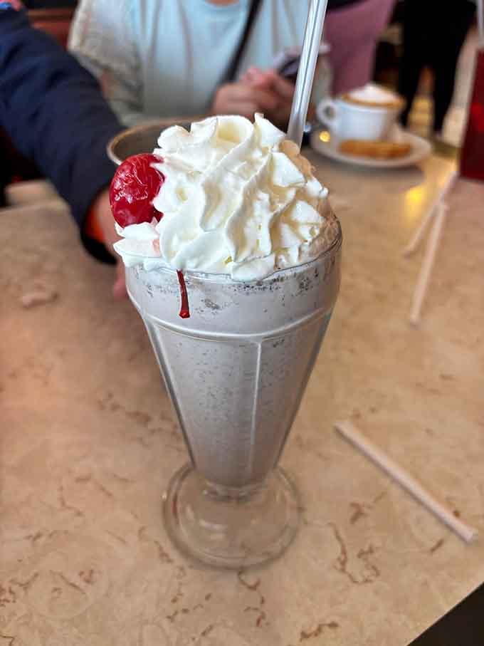 This milkshake stands tall and proud, crowned with whipped cream like it just won the dairy dessert Olympics.
