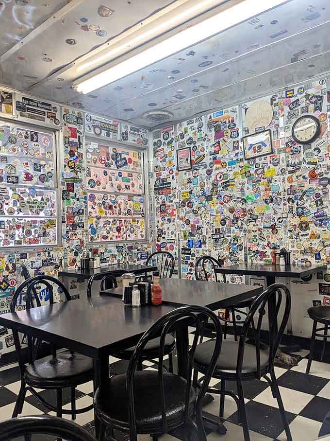 The sticker-covered walls create a visual time capsule where every surface celebrates decades of pop culture and local history.