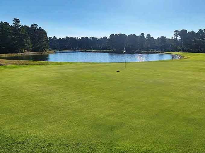 Golf course green meeting water hazard in a landscape that makes three-putting almost forgivable, almost.