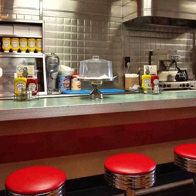 The classic diner counter setup with condiments at the ready, because good food deserves proper accompaniments always.