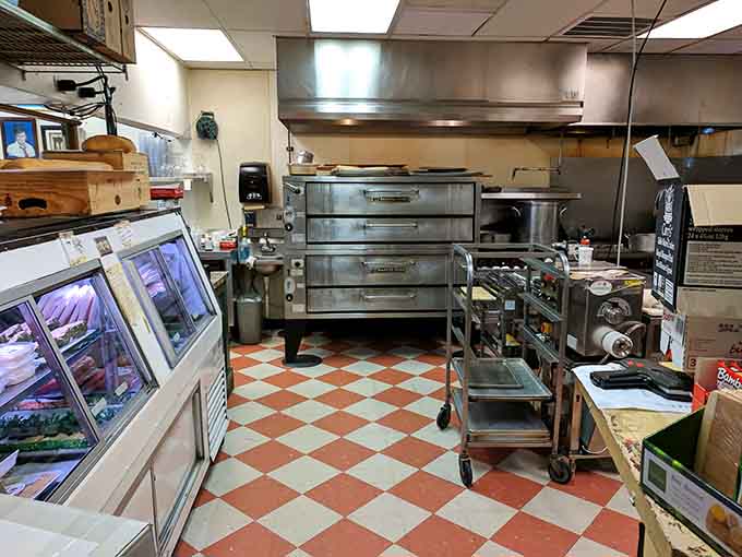 A working kitchen with checkered floors and serious equipment. This is where those house-made sausages and salamis come to life.