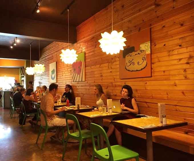 A diverse crowd enjoying their meals proves the Green Owl's appeal transcends dietary labels and brings everyone to the table.