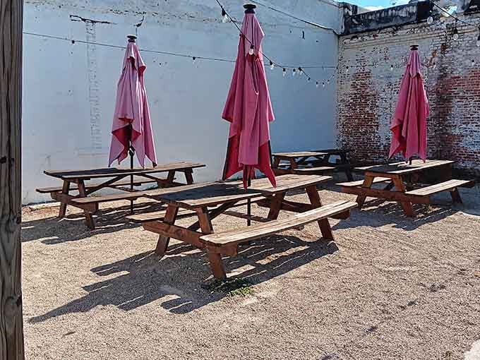 Outdoor picnic tables with pink umbrellas, because even hot dog stands deserve a little personality and charm.