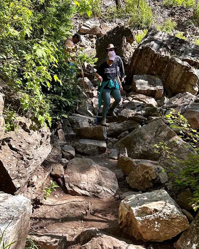 Real hikers tackling real elevation gain—notice the trekking poles and determined expressions of victory.