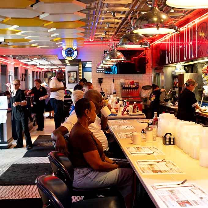 Counter seating offers front-row views of breakfast theater, where eggs and conversation flow equally well.