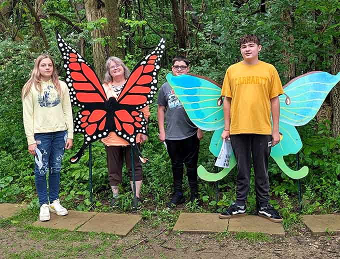 Visitors pose with colorful butterfly wings, adding whimsy to their exploration of Ohio's remarkable prehistoric engineering achievements.