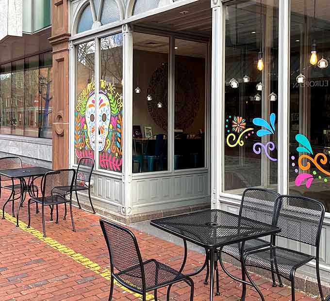 Outdoor seating with cheerful window art invites you to enjoy your chocolate while watching Salem's historic streets.