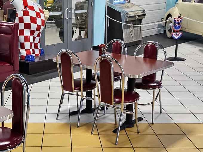 Chrome-trimmed tables and burgundy chairs line up like soldiers, ready to serve hungry patrons surrounded by automotive history and nostalgia.