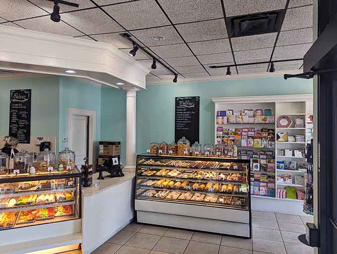 Display cases overflow with colorful macarons arranged like edible rainbows, each one a tiny, perfect sandwich cookie.