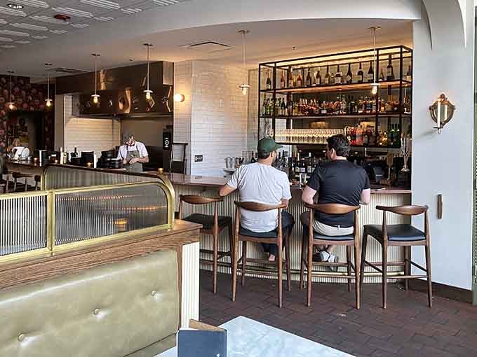 The backlit bar shelves showcase bottles like a museum display, inviting exploration and discovery.