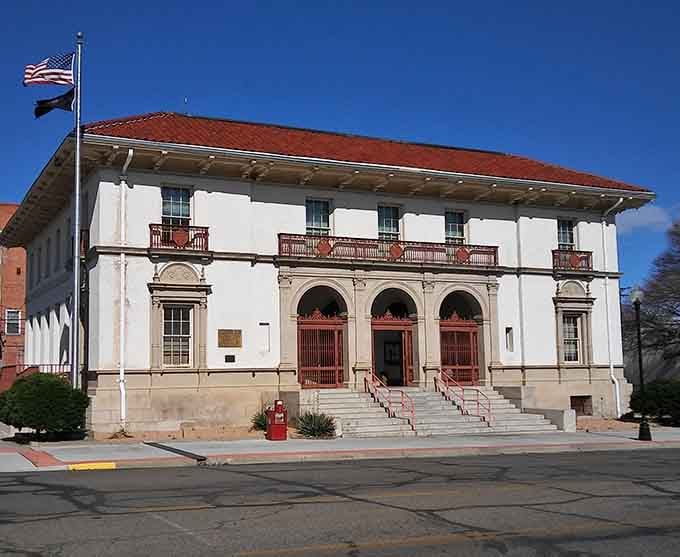 The historic La Junta Post Office stands tall under a clear blue sky, showcasing its beautiful Mediterranean-style architecture and charm.
