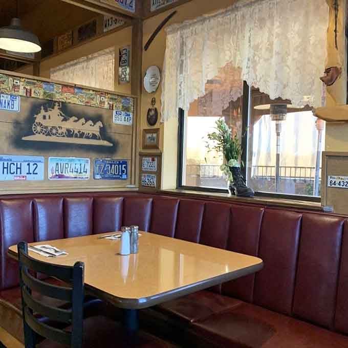 Sunlight streams through lace curtains onto burgundy booths, inviting you to settle in for a spell.