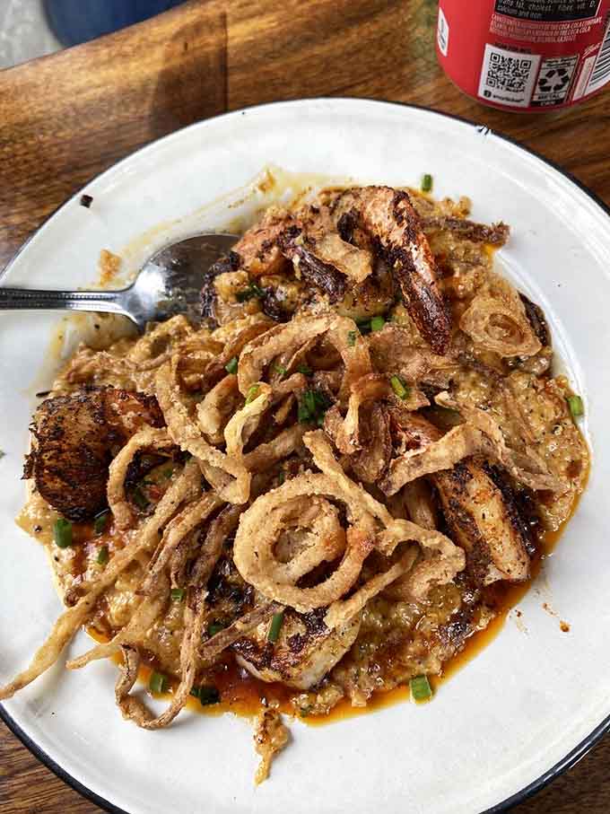 Shrimp and grits topped with crispy onions, a dish that understands comfort food should never be boring.