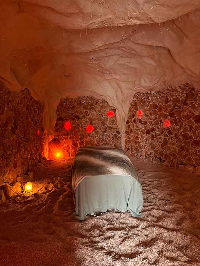 Even the massage table gets the salt cave treatment, surrounded by glowing walls for ultimate therapeutic relaxation sessions.
