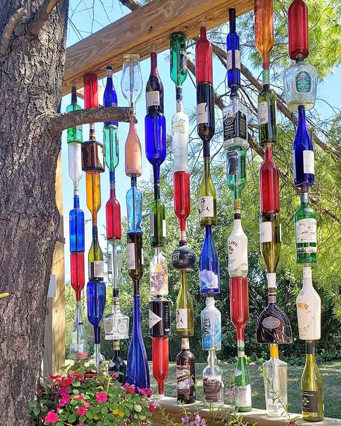 Recycled bottle art catching the light creates a surprisingly elegant display that's part wind chime, part environmental statement.