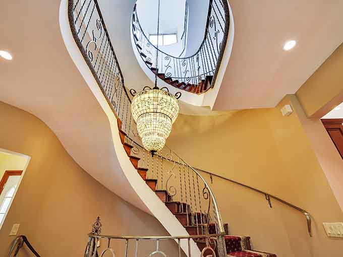 This spiral staircase with its cascading chandelier makes every descent feel like a grand entrance to the ball.