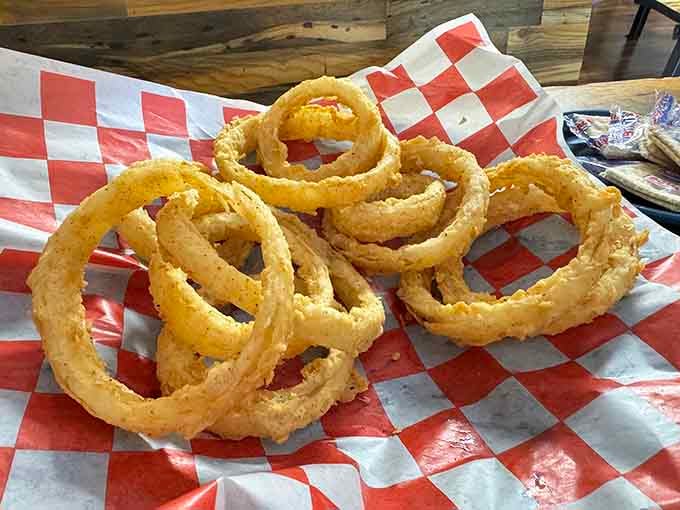 Golden, crispy onion rings stacked high like edible architecture that belongs in the fried food hall of fame.
