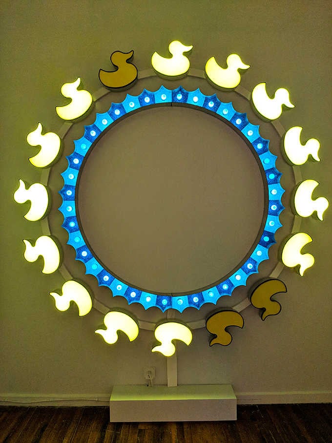 Illuminated ducks circling endlessly, creating a meditation on motion that's oddly mesmerizing and completely delightful.