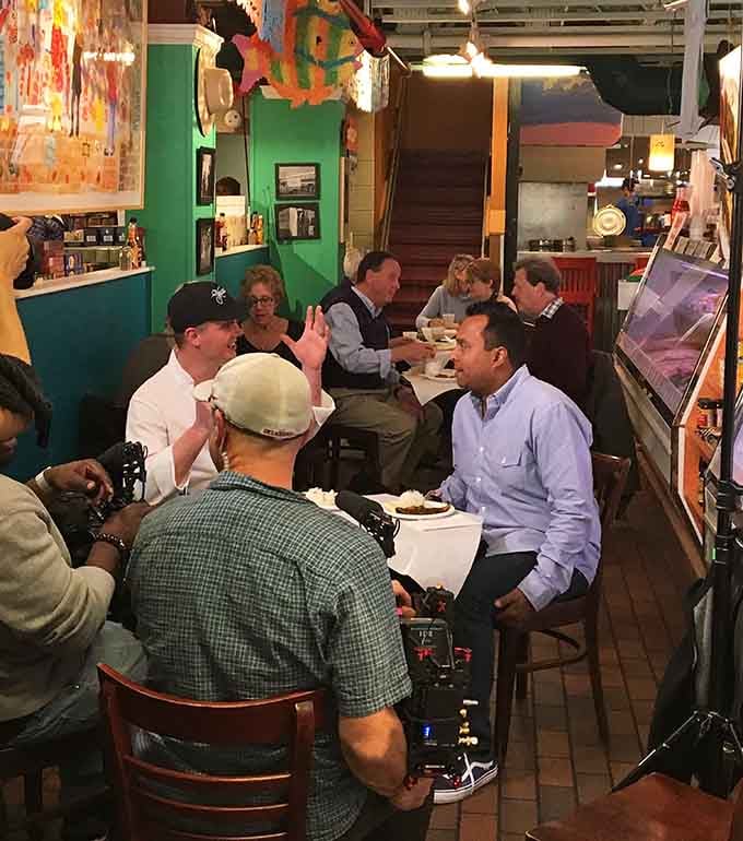 Diners gather around colorful tables, sharing meals and stories in this beloved community gathering spot.