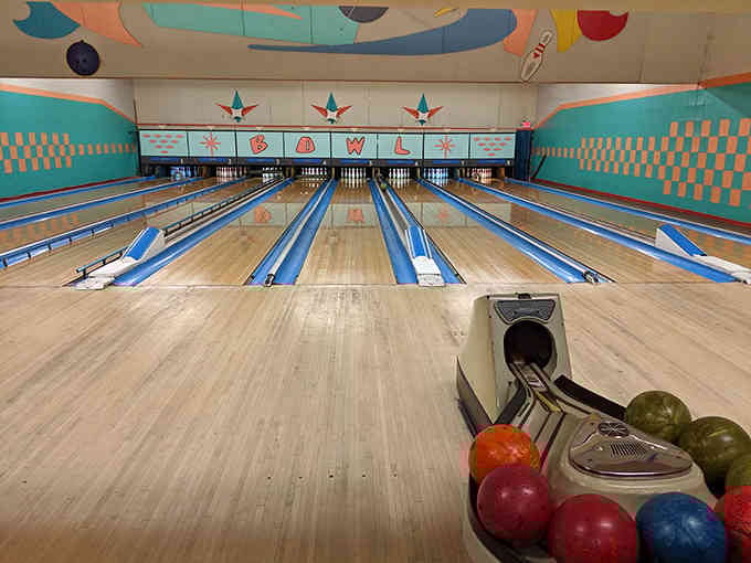 Colorful bowling balls lined up like candy, each one waiting to knock down some pins.