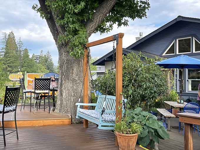 That charming patio swing under the trees makes waiting for your table feel like a vacation moment.