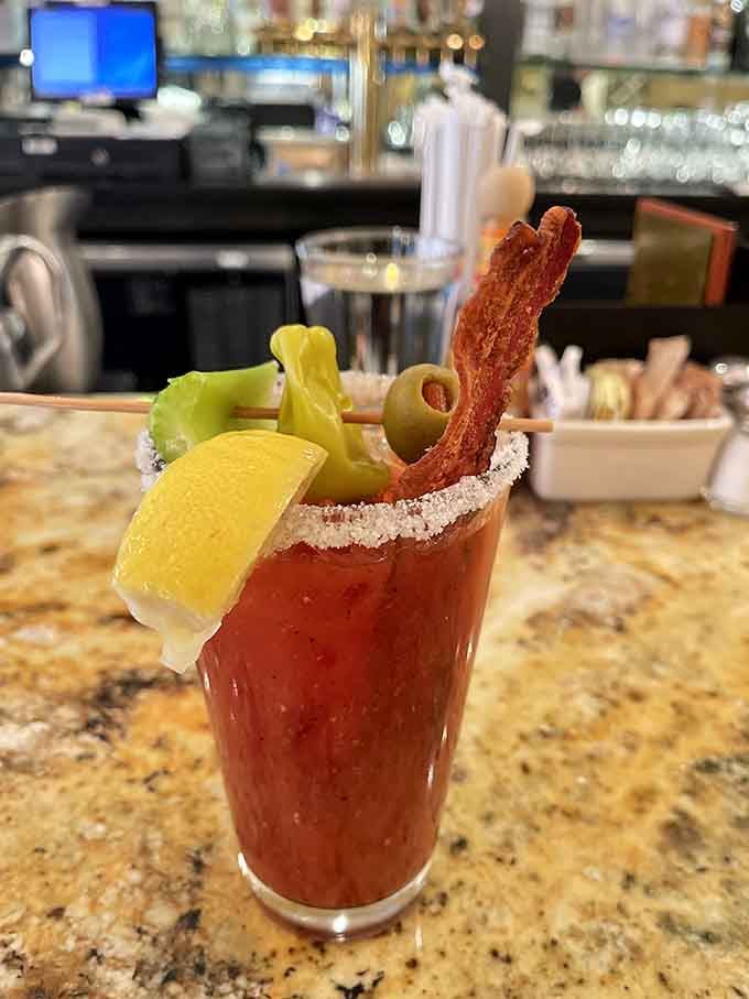The Bloody Mary arrives dressed to impress, complete with bacon, pickles, and enough garnishes for a small salad.