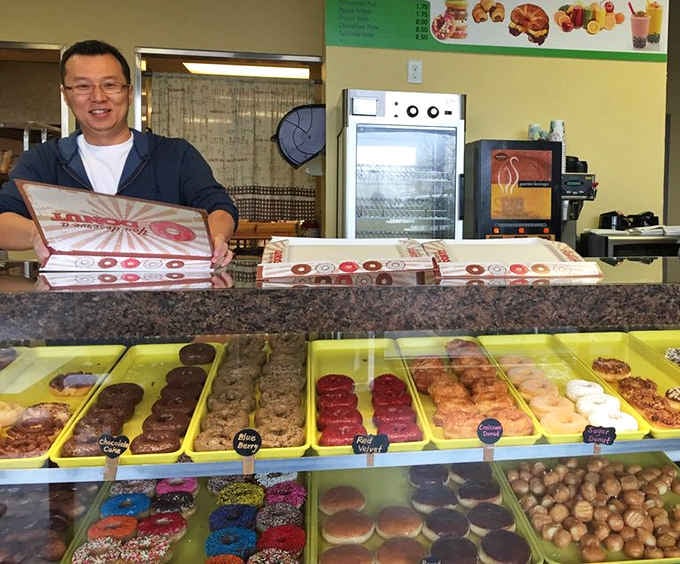 That smile says it all: fresh boxes ready, donuts waiting, and another satisfied customer about to leave very happy.