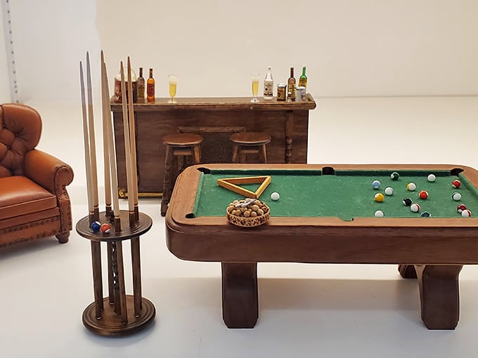 A perfectly scaled billiards table complete with cue sticks and balls, ready for the world's smallest pool tournament.