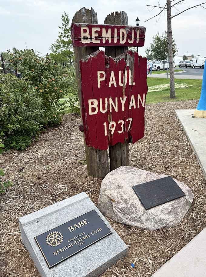 The rustic marker has weathered nearly as many seasons as the statues themselves, earning its stripes through Minnesota winters.