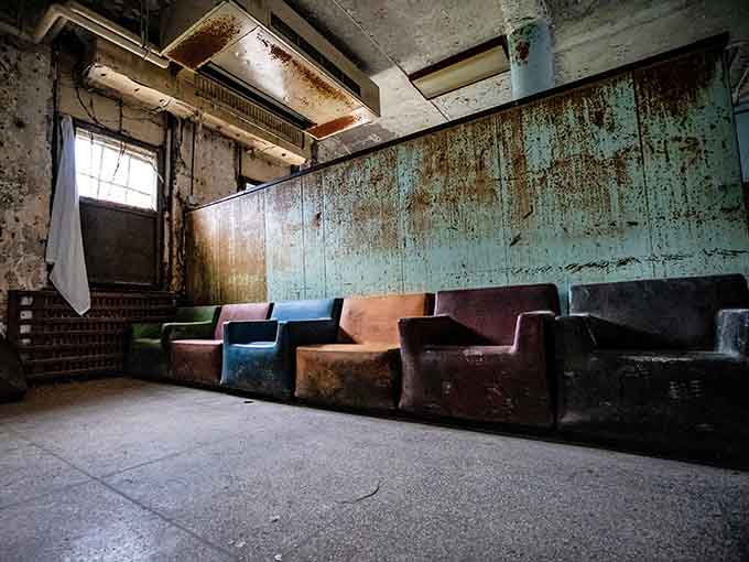 Colorful armchairs line the wall like forgotten guests at a party nobody wants to attend anymore.