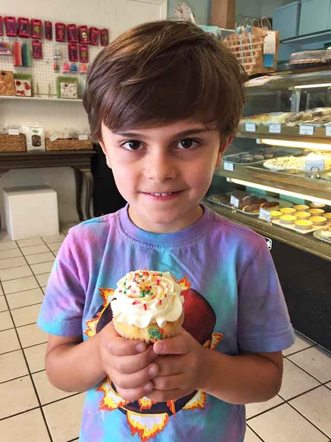 Pure joy captured in sprinkles and frosting, held by hands that know good cupcakes when they see them.